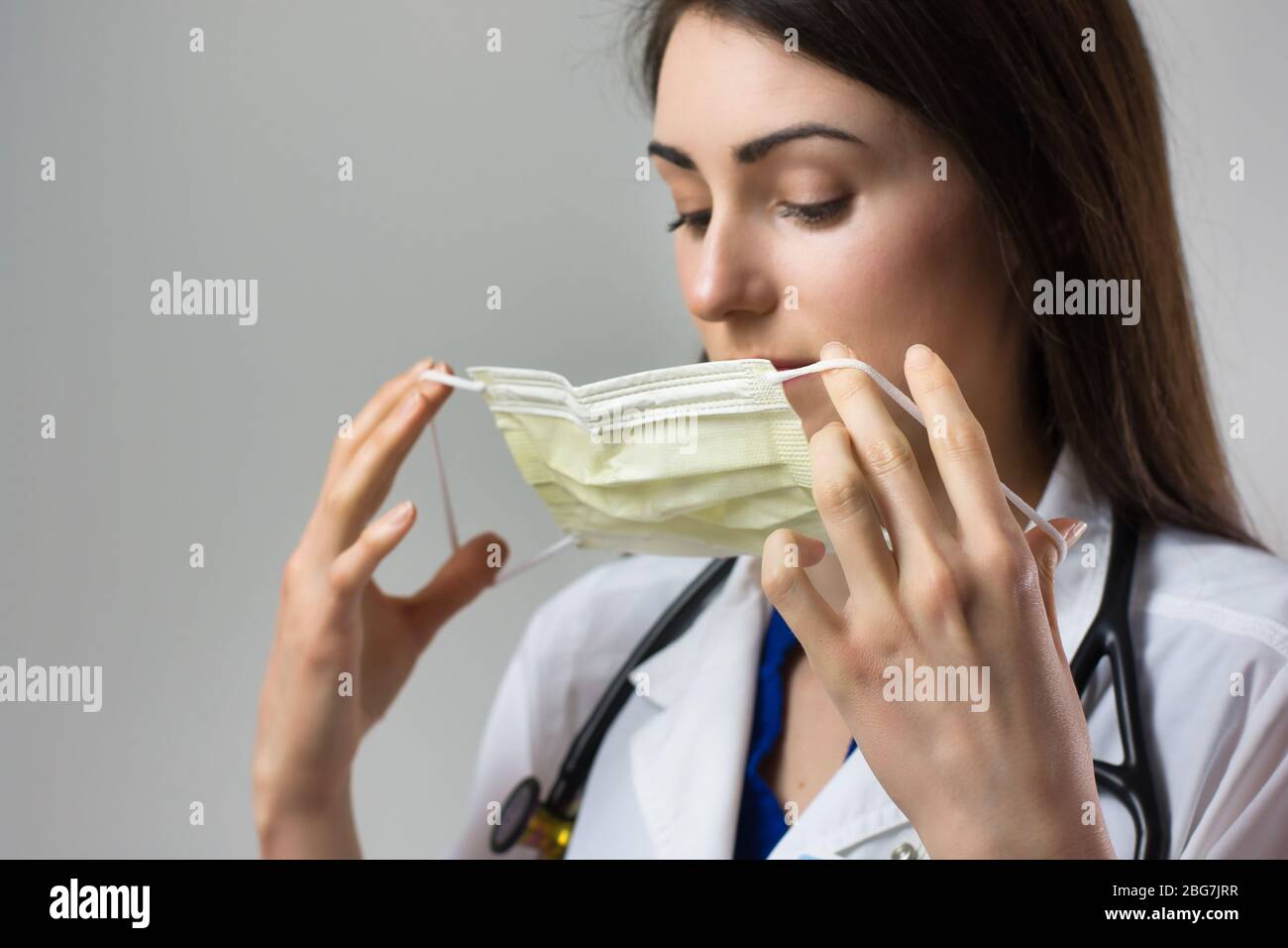 Woman healthcare professional demonstrating proper donning of mask for ...