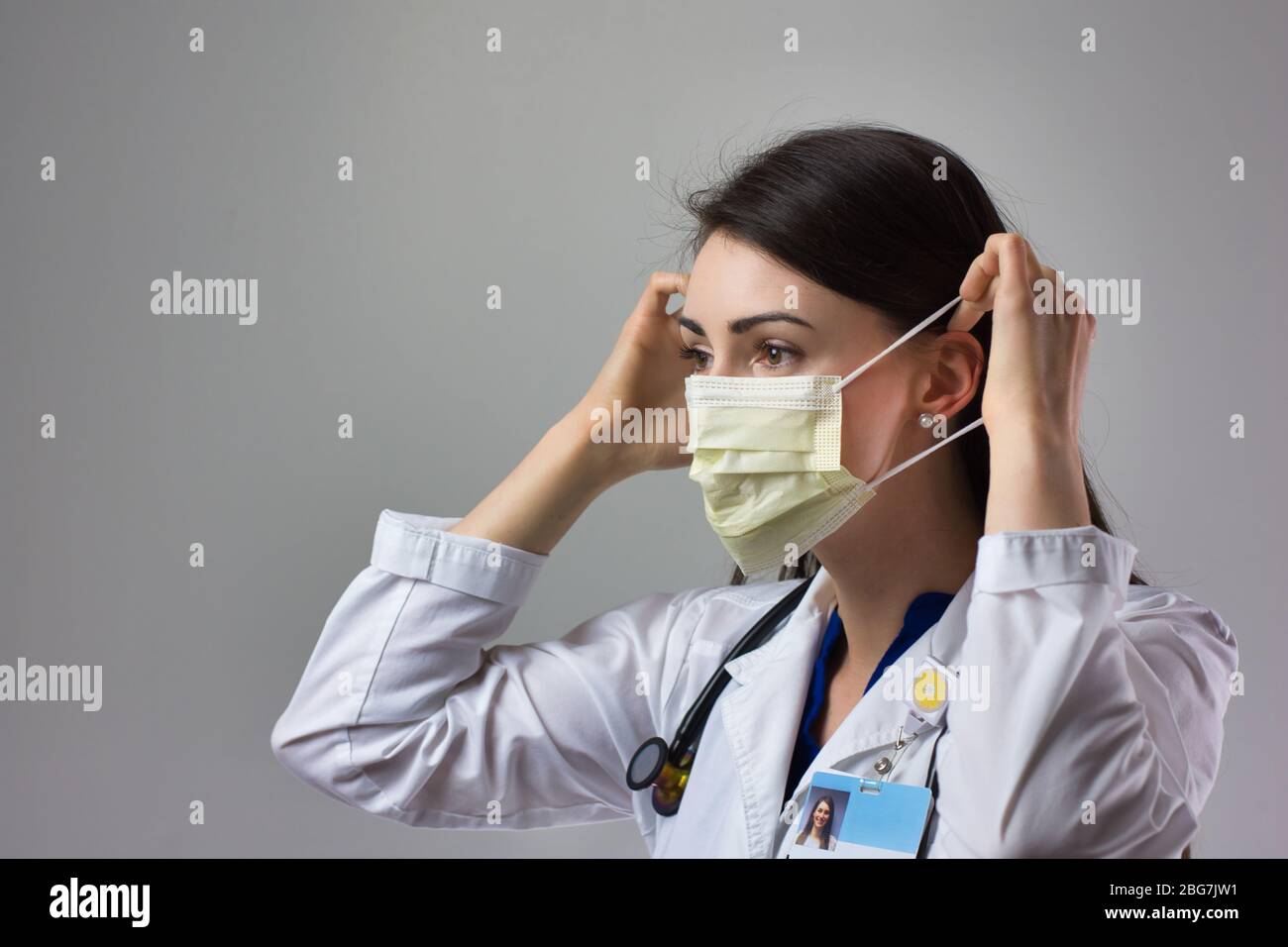 Woman healthcare professional demonstrating proper donning of mask for ...