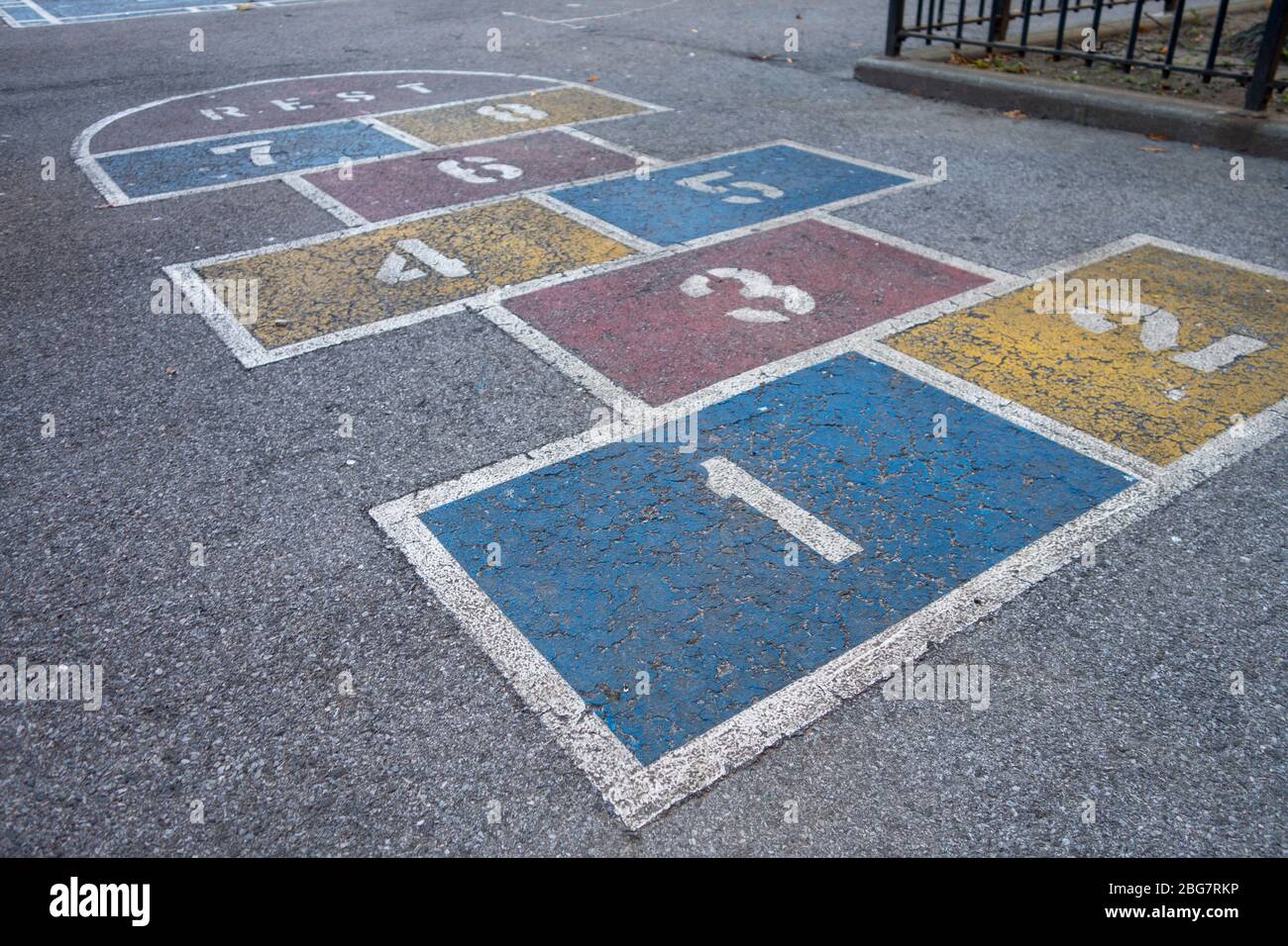 hop-scotch childern's game on school yard asphalt with colored squares ...