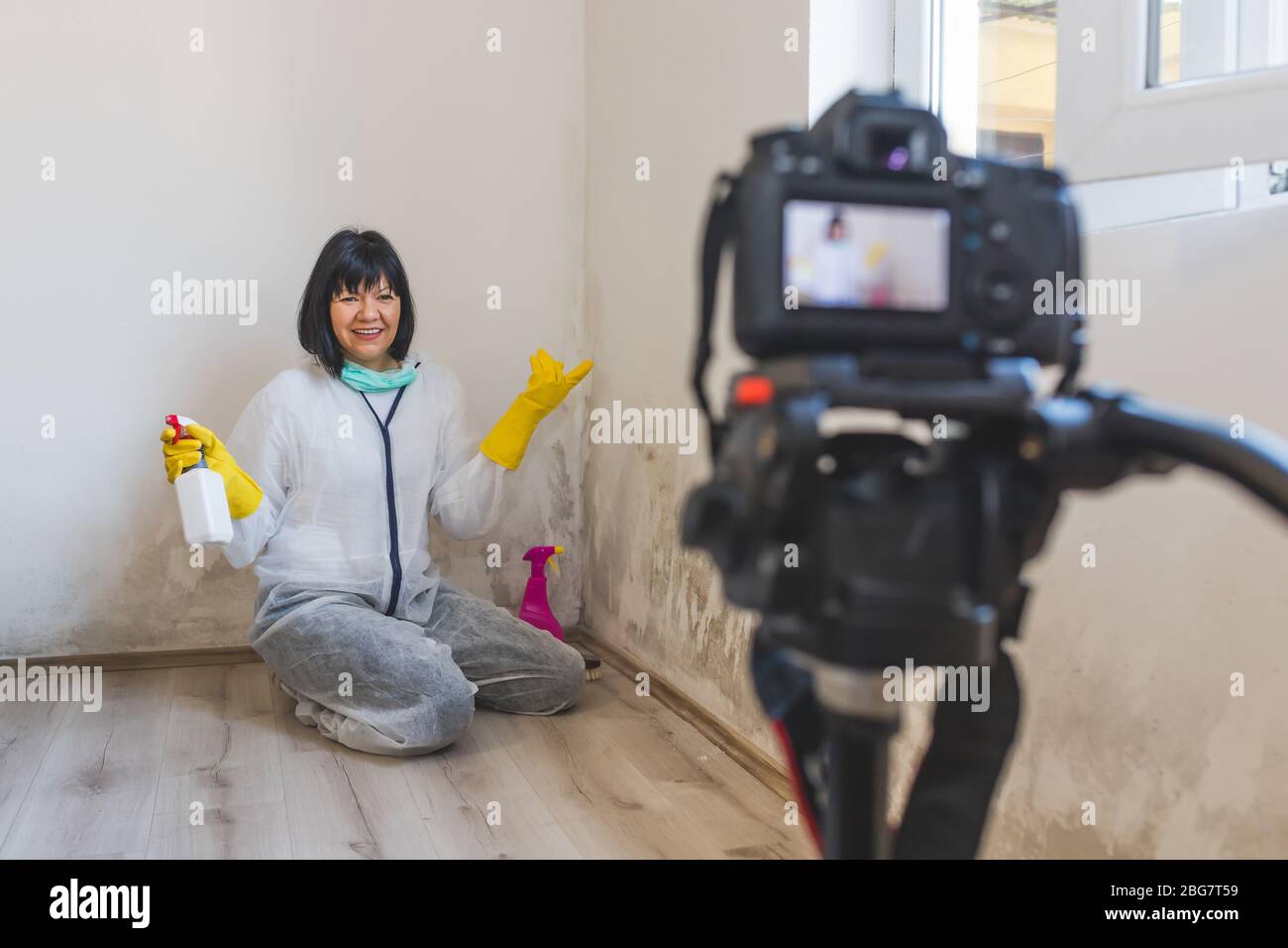 Video camera filming how woman cleaning mold from wall using spray ...