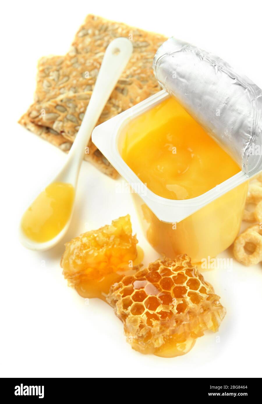 Tasty dessert in open plastic cup and honey combs, isolated on white ...