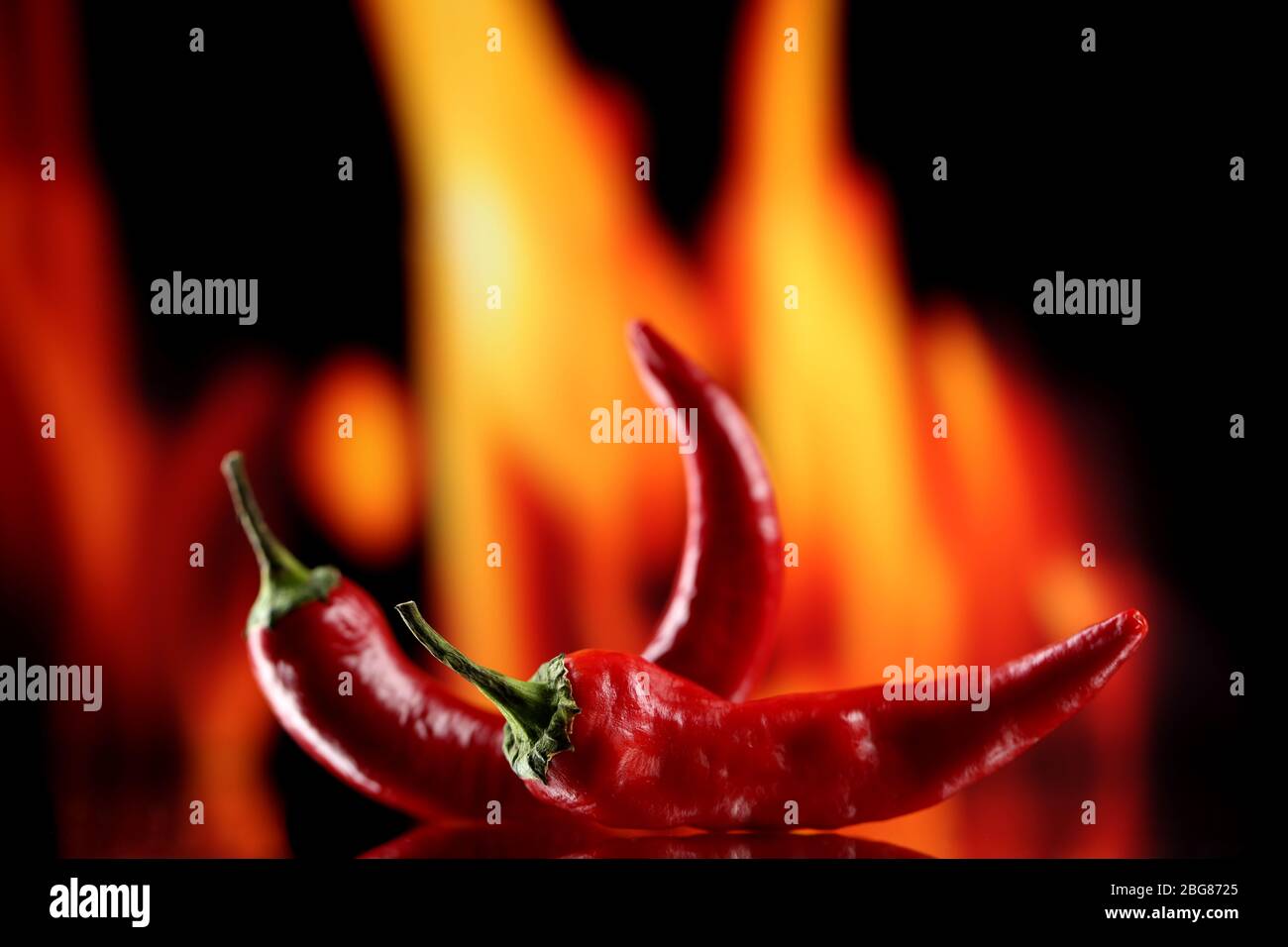 Red hot chili peppers on fire background Stock Photo - Alamy