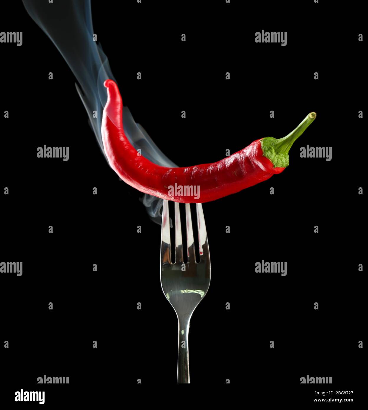 Red hot chili pepper on fork, isolated on black Stock Photo - Alamy