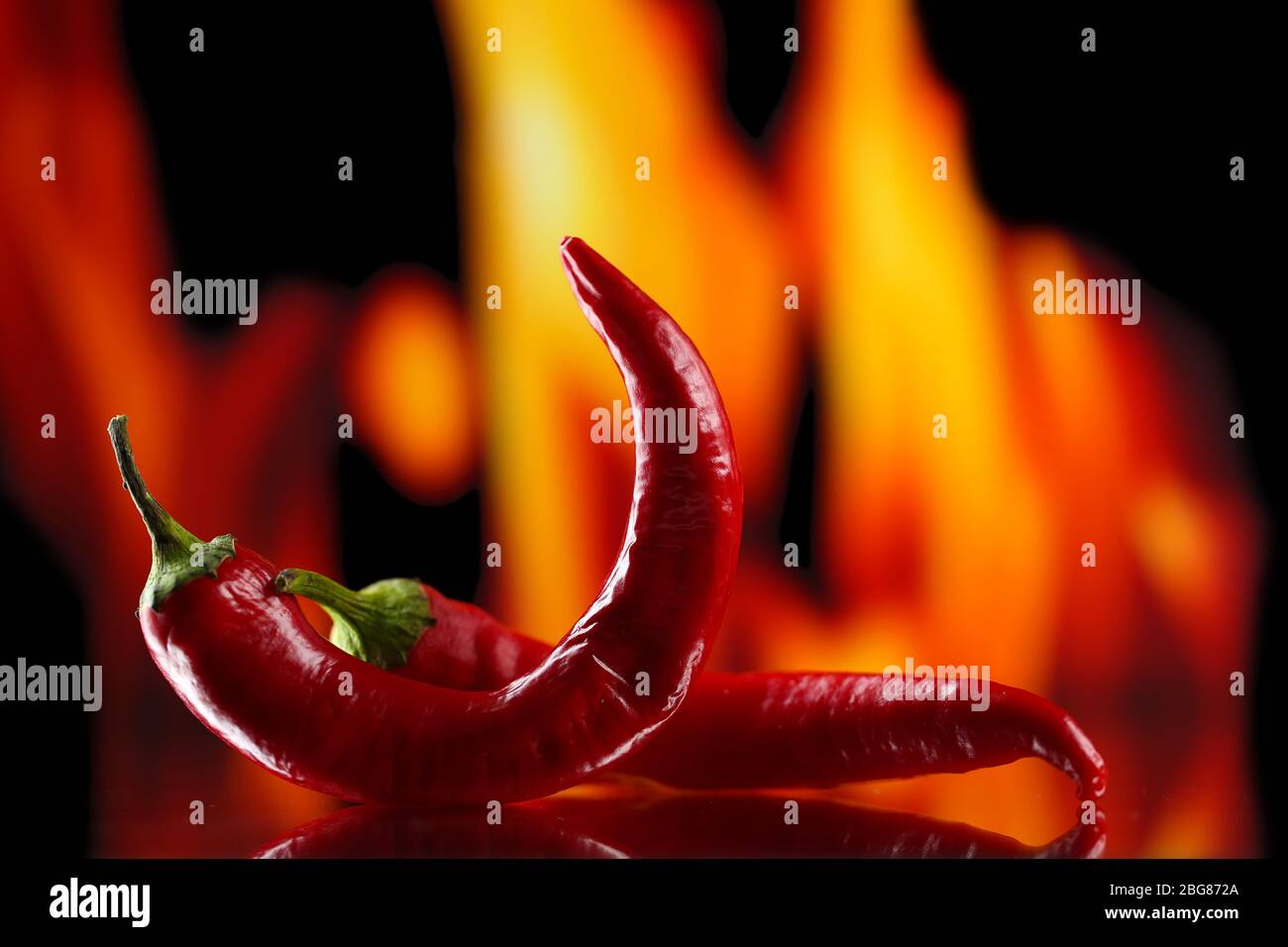 Red hot chili peppers on fire background Stock Photo - Alamy