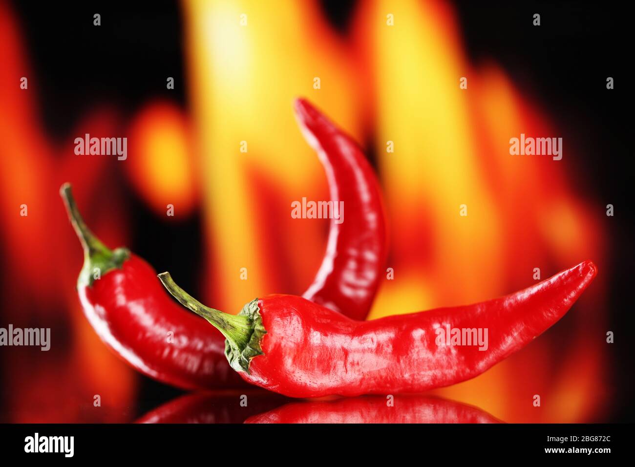 Red hot chili peppers on fire background Stock Photo - Alamy
