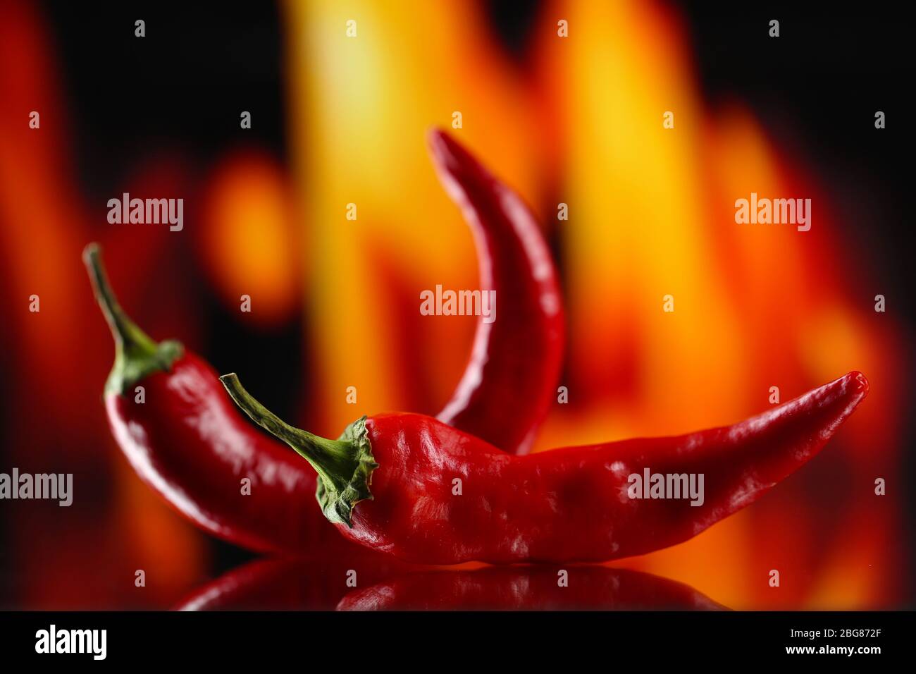 Red hot chili peppers on fire background Stock Photo - Alamy