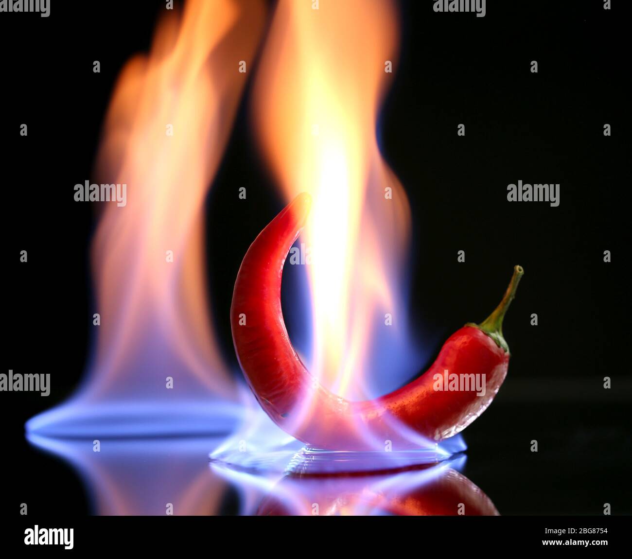 Red hot chili pepper on fire, isolated on black Stock Photo - Alamy