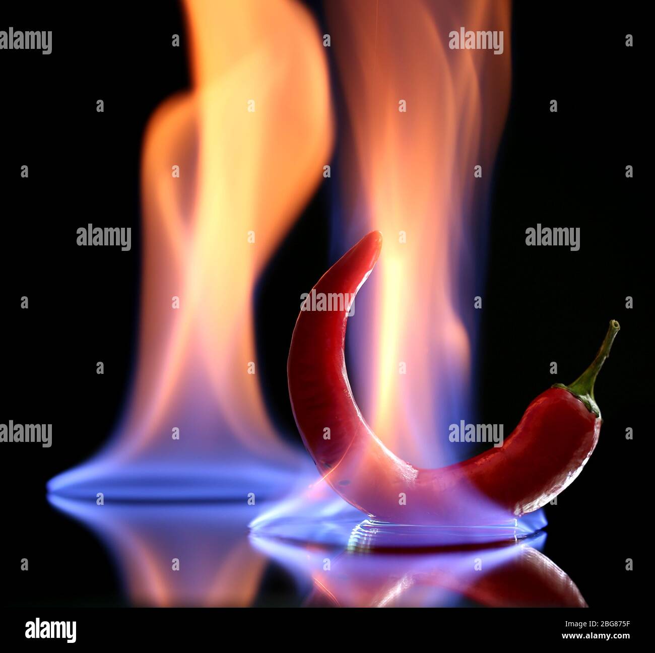 Red hot chili pepper on fire, isolated on black Stock Photo - Alamy
