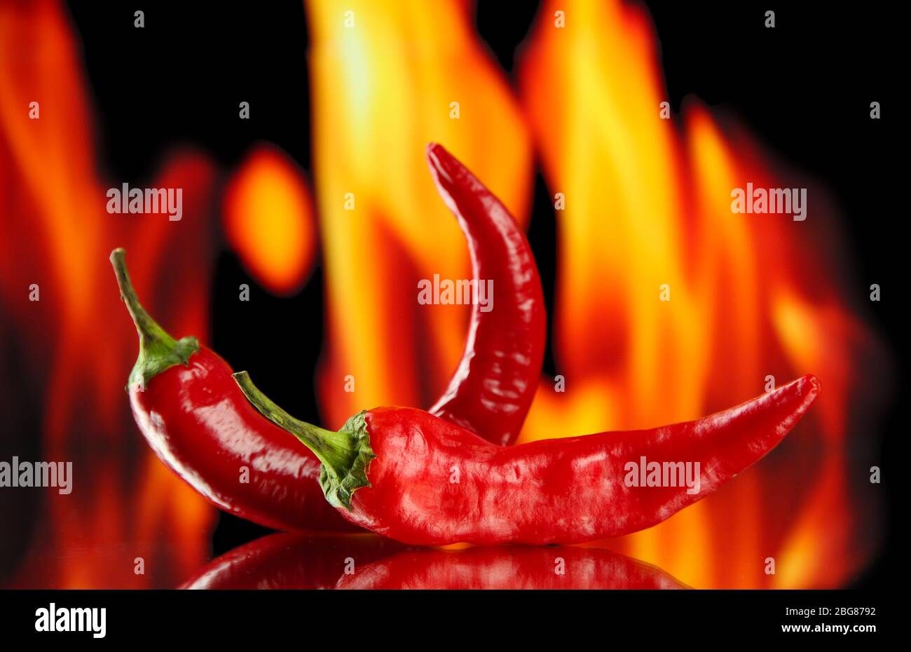 Red hot chili peppers on fire background Stock Photo - Alamy