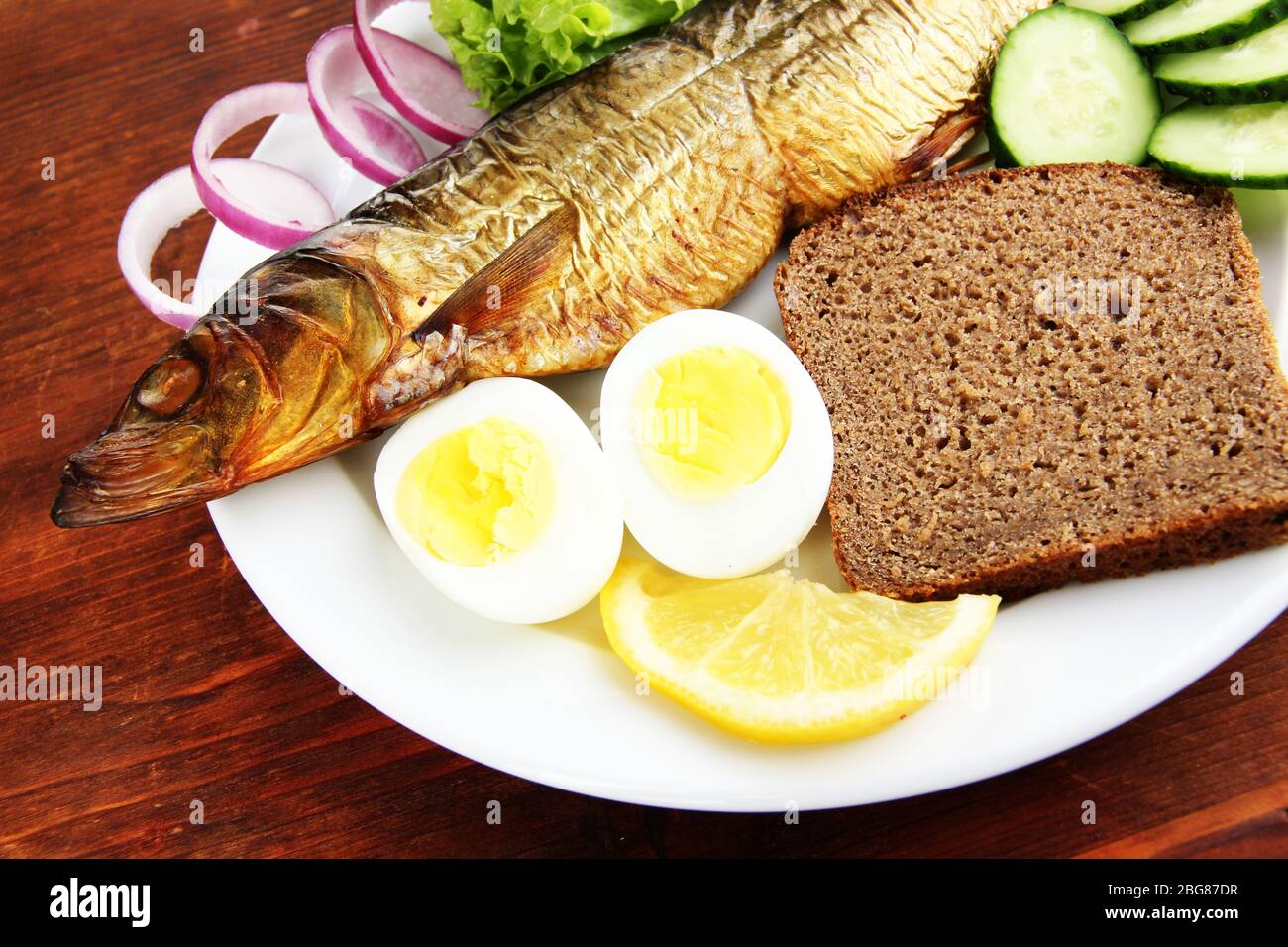 Smoked fish on plate close up Stock Photo - Alamy
