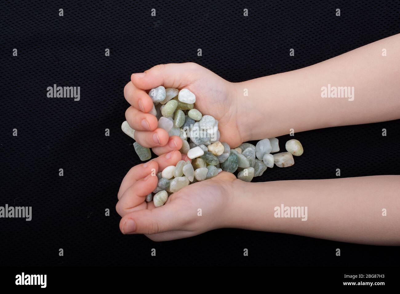 Handful of clean pebbles, gravels in hands Stock Photo - Alamy