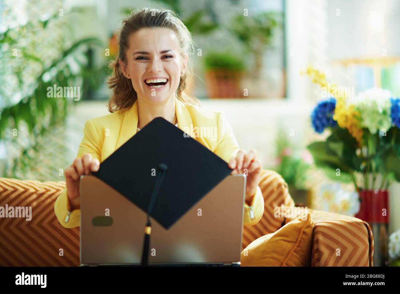 smiling young student in jeans and yellow jacket at modern home in ...