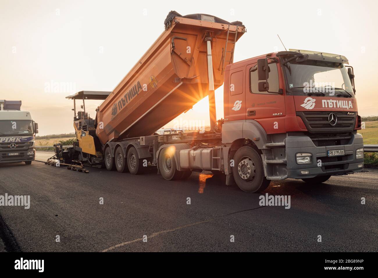 road construction workers operating pavement machine. highway ...