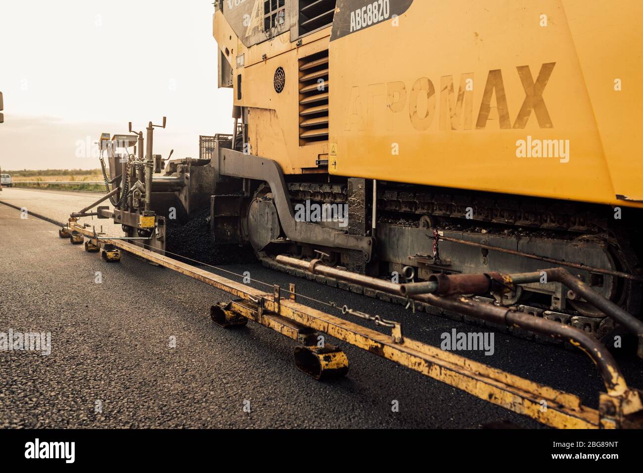 road construction workers operating pavement machine. highway ...