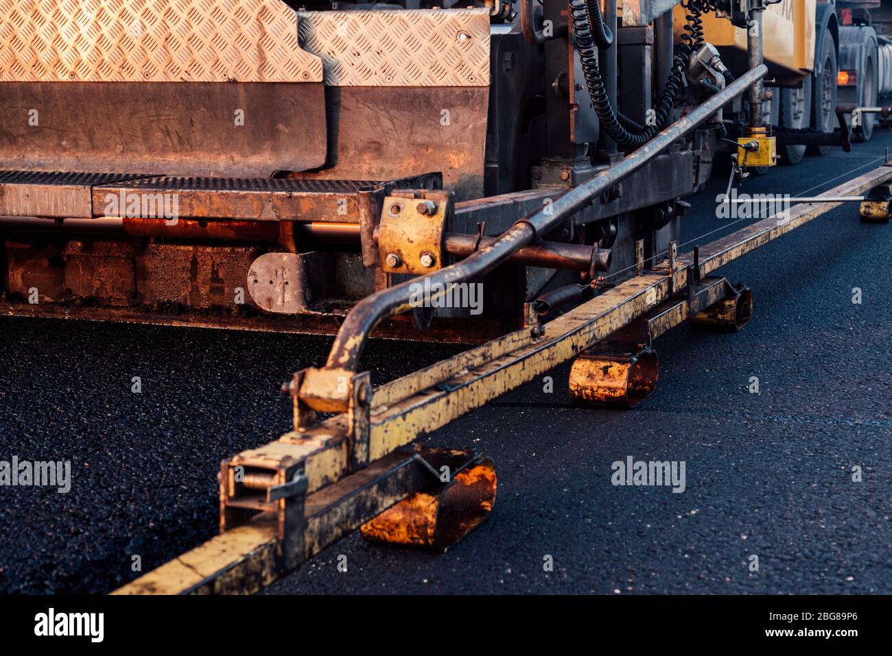road construction workers operating pavement machine. highway ...
