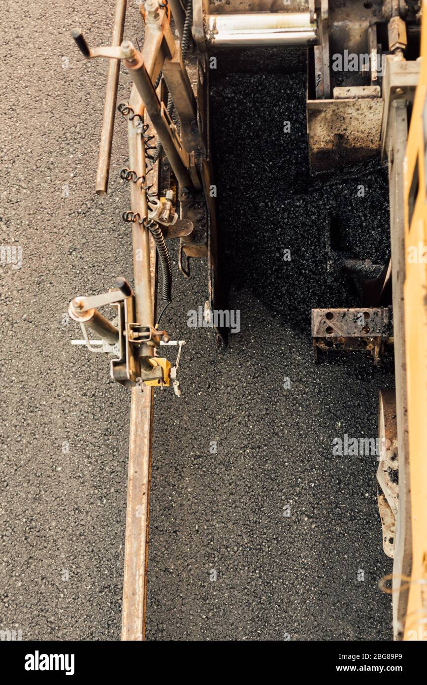 road construction workers operating pavement machine. highway ...