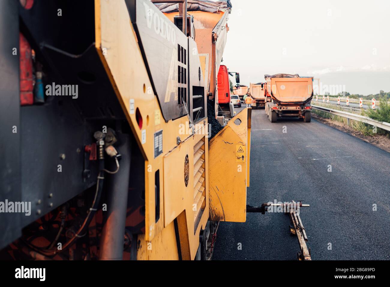 road construction workers operating pavement machine. highway ...