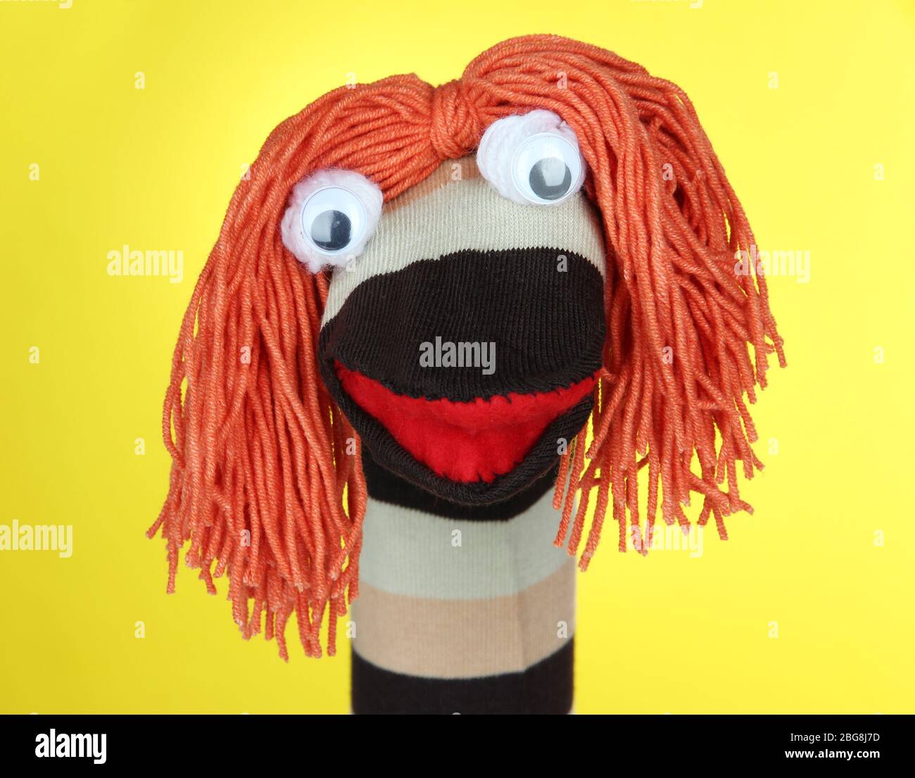 Cute sock puppet on yellow background Stock Photo - Alamy
