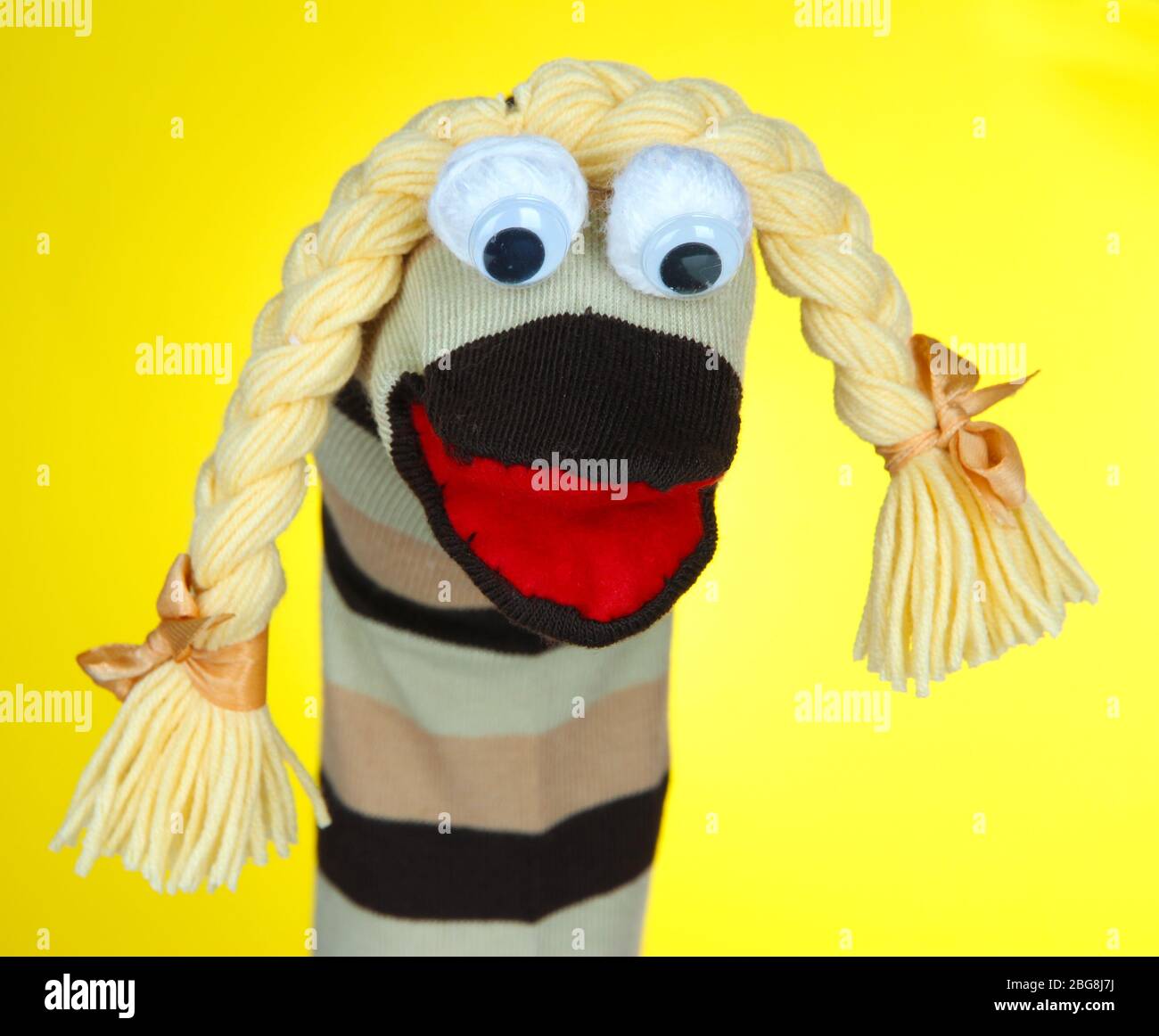 Cute sock puppet on yellow background Stock Photo - Alamy
