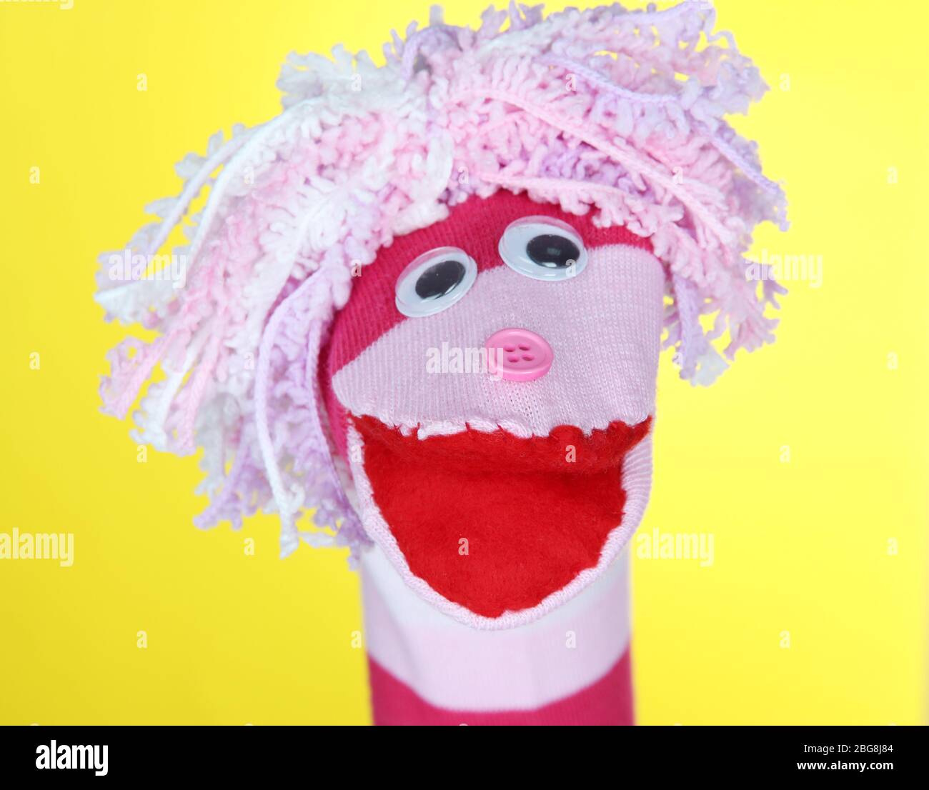 Cute sock puppet on yellow background Stock Photo - Alamy