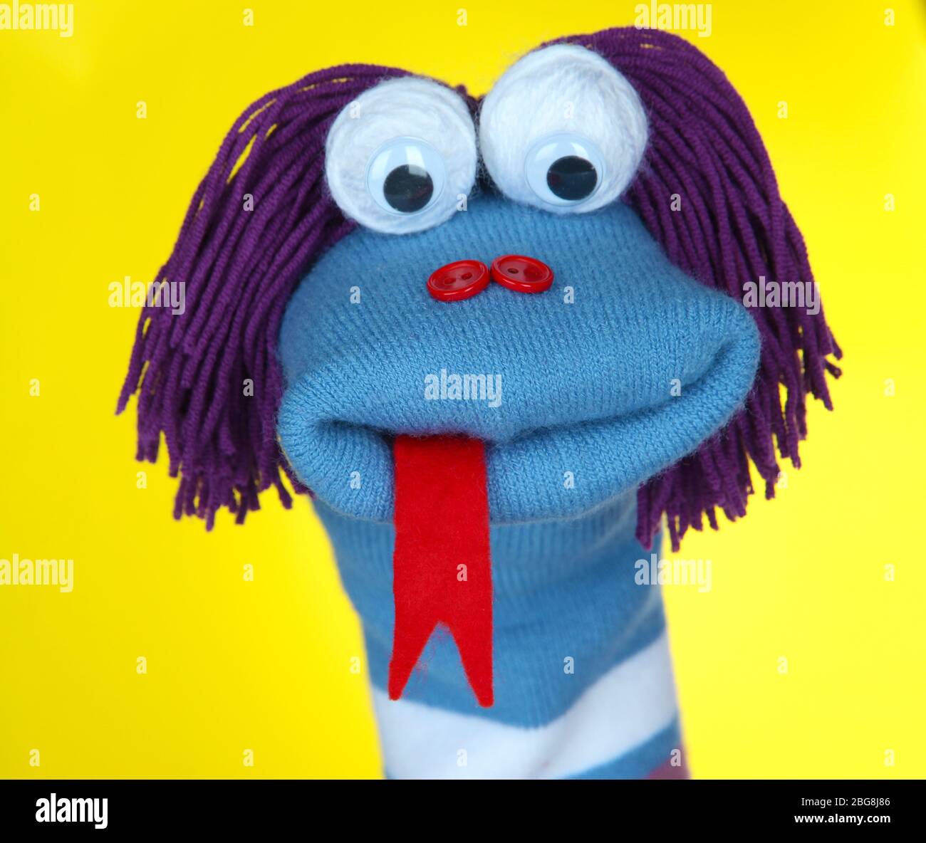 Cute sock puppet on yellow background Stock Photo - Alamy