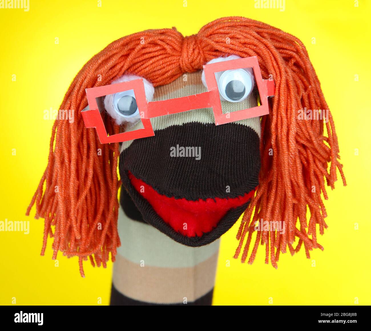 Cute sock puppet on yellow background Stock Photo - Alamy