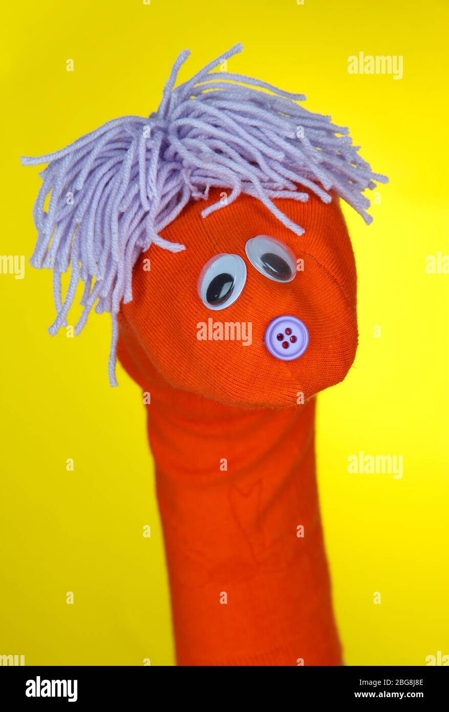 Cute sock puppet on yellow background Stock Photo - Alamy