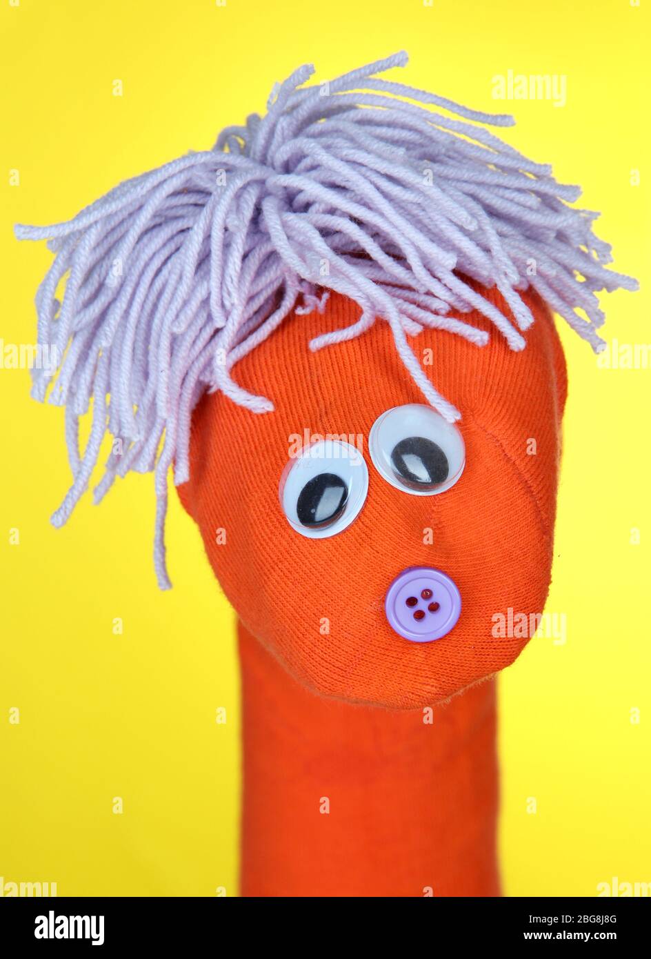 Cute sock puppet on yellow background Stock Photo - Alamy