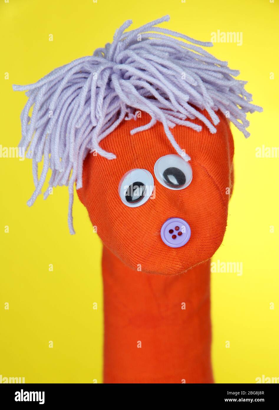 Cute sock puppet on yellow background Stock Photo - Alamy