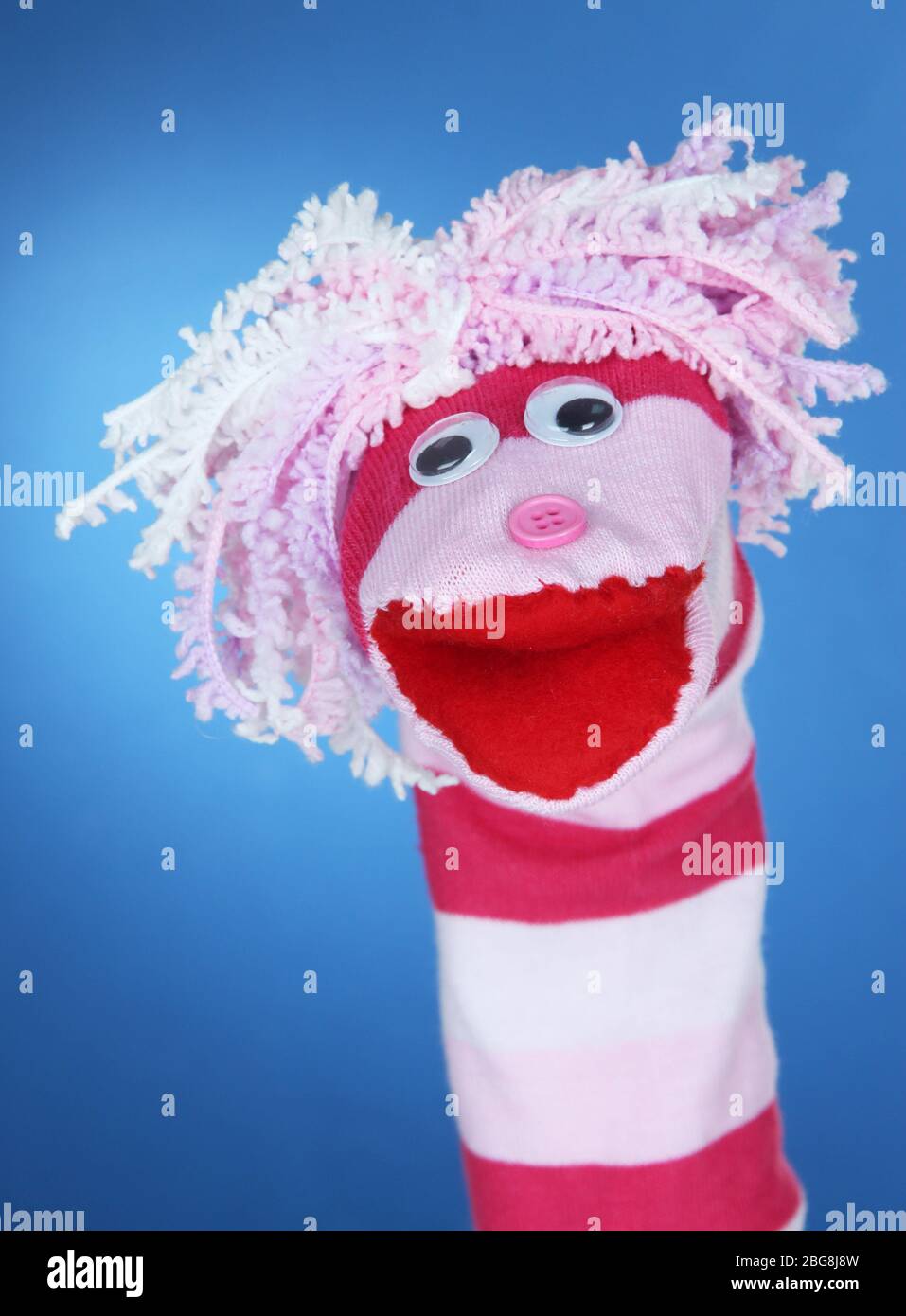 Cute sock puppet on blue background Stock Photo - Alamy