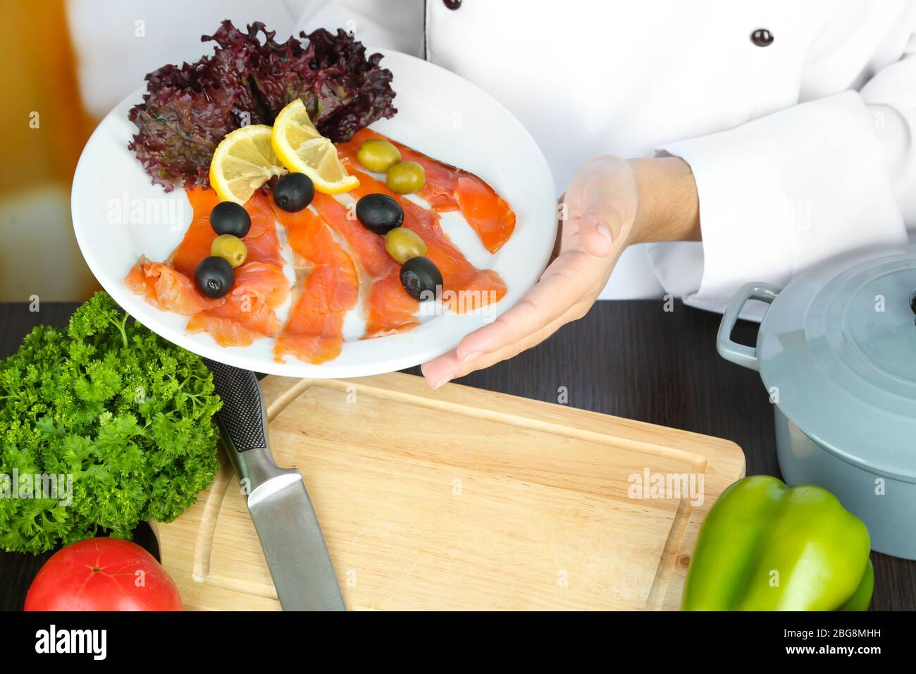 Cook hands holding dish at workplace Stock Photo - Alamy