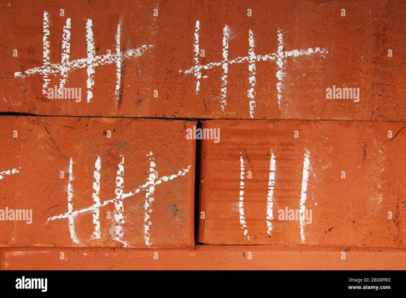 Counting days by drawing sticks on bricks close up Stock Photo - Alamy