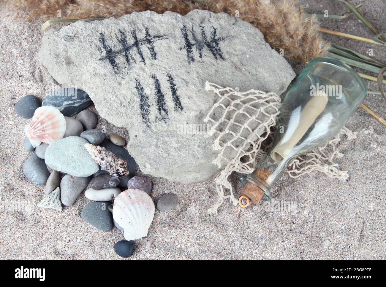 Counting days by drawing sticks on stone with stones and shells on sand ...