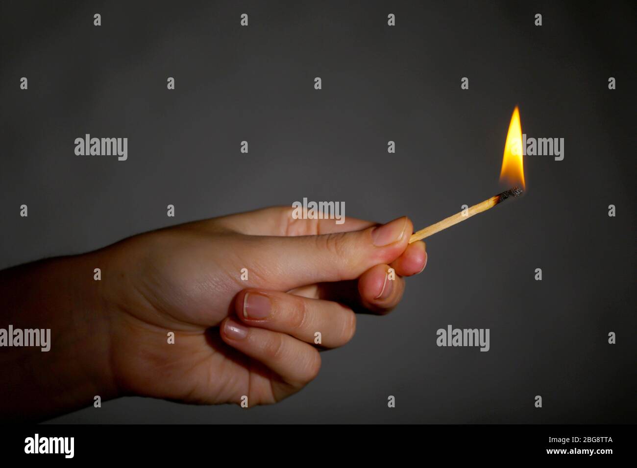 Burning match in hand on black background Stock Photo - Alamy