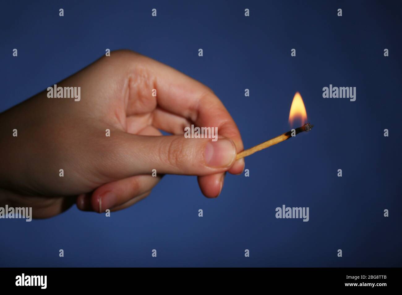 Burning match in hand on black background Stock Photo - Alamy