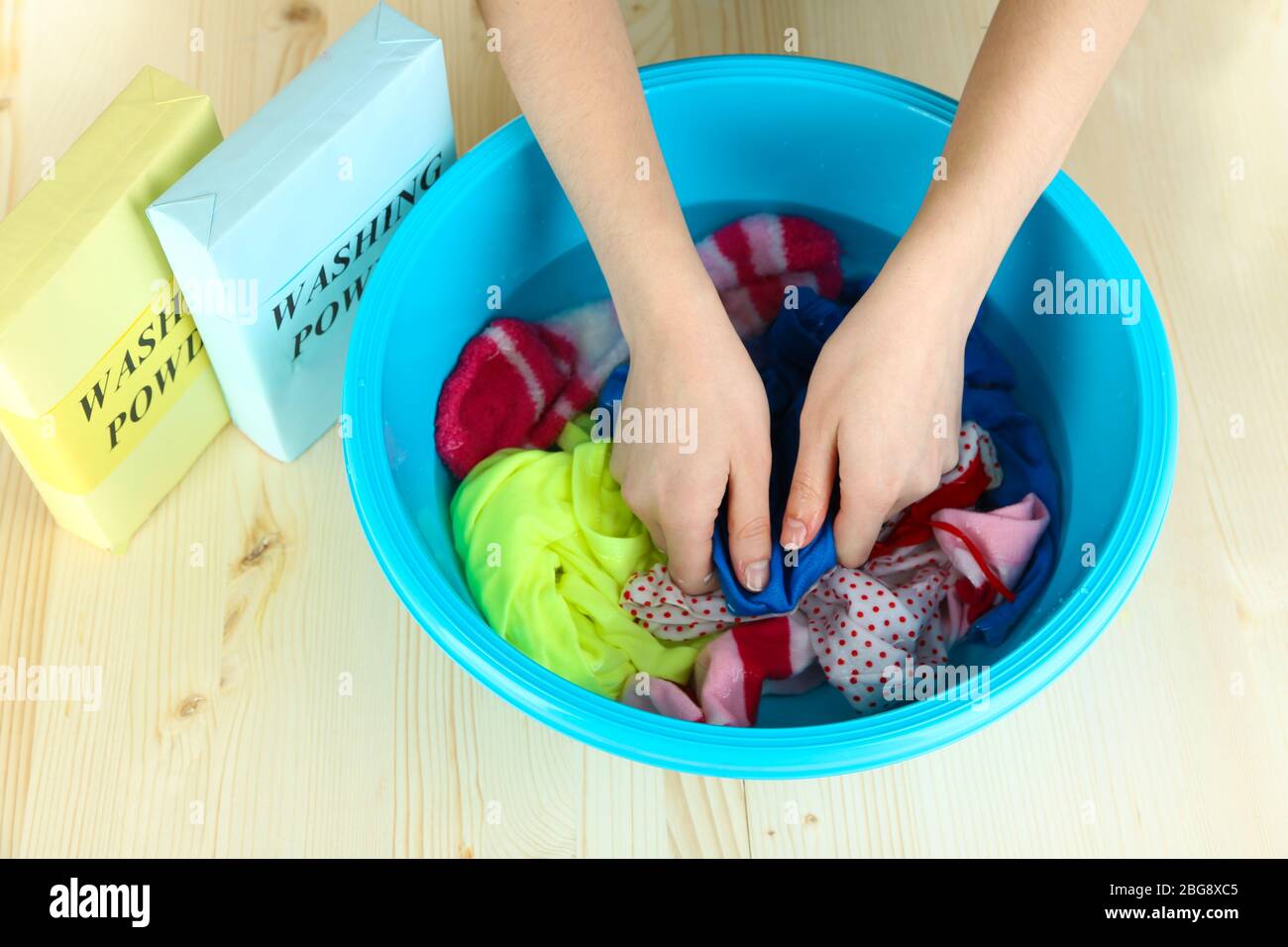 Hand washing in plastic bowl on wooden table close-up Stock Photo - Alamy
