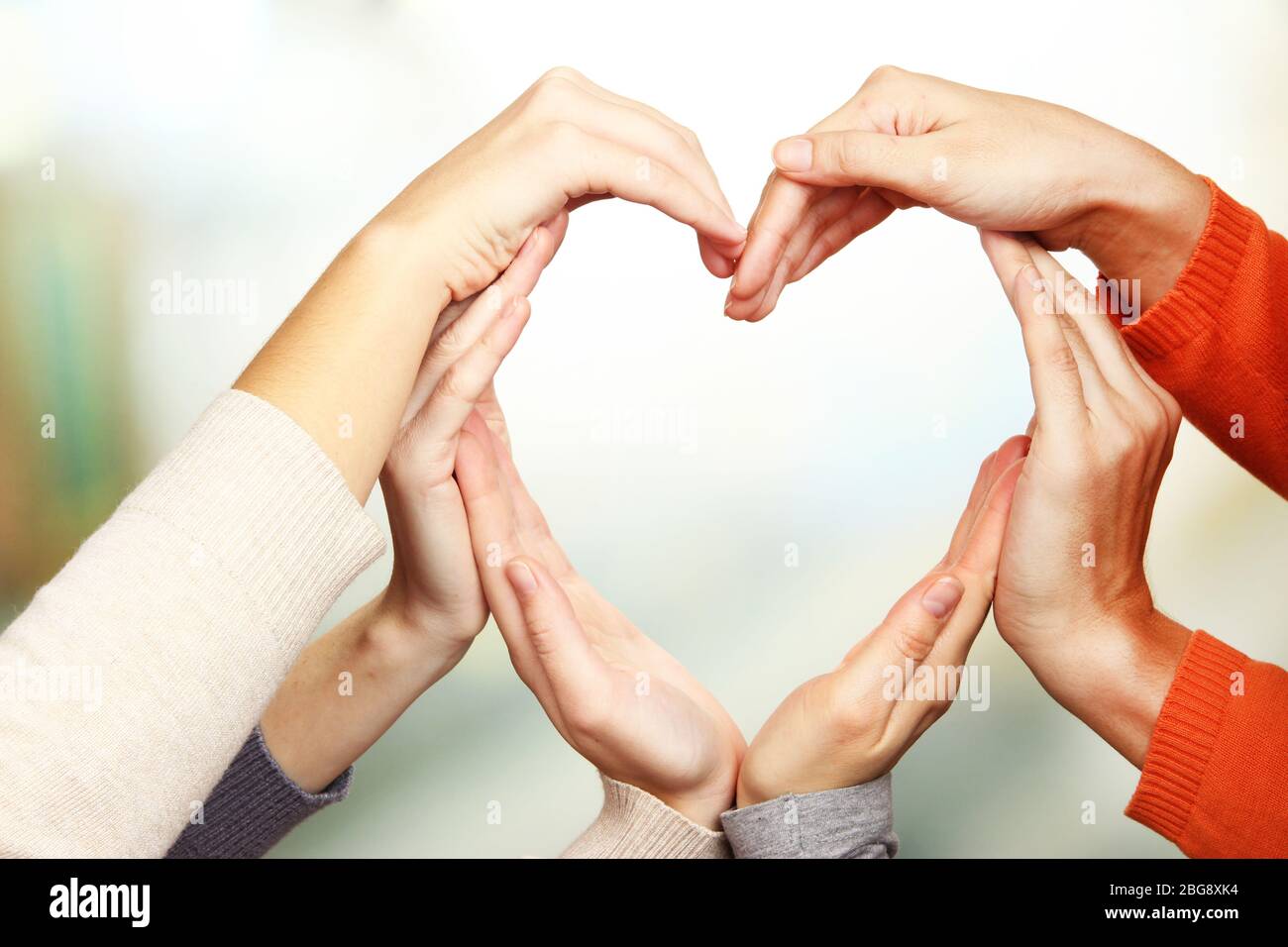 Human hands in heart shape on bright background Stock Photo - Alamy