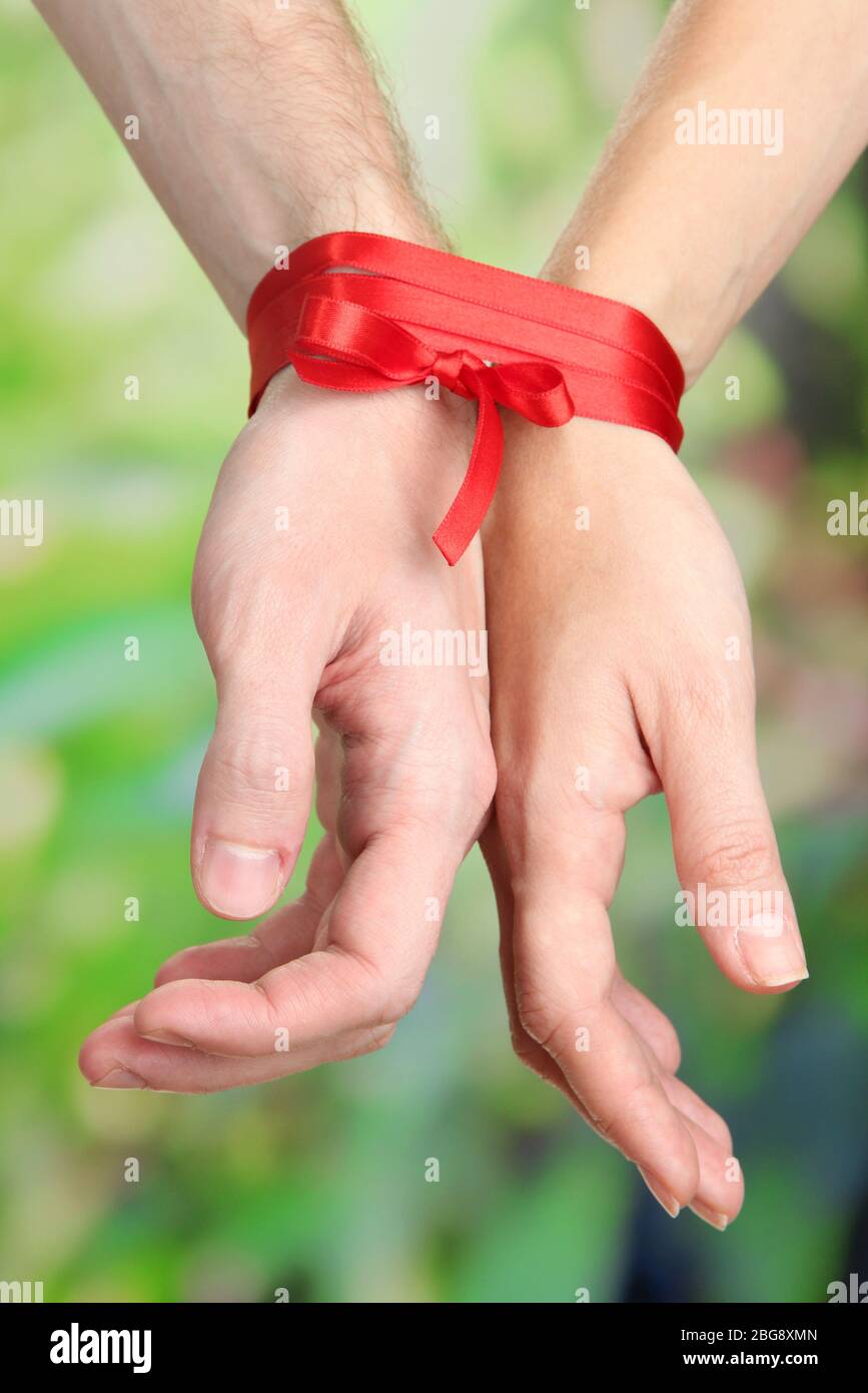Mans and girls hands tied with ribbon on bright background Stock Photo ...