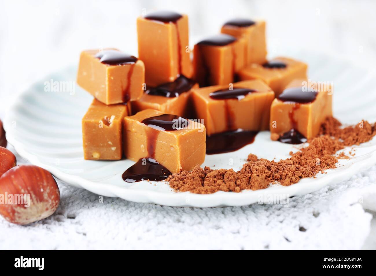 Many toffee on plate on napkin on wooden table Stock Photo - Alamy