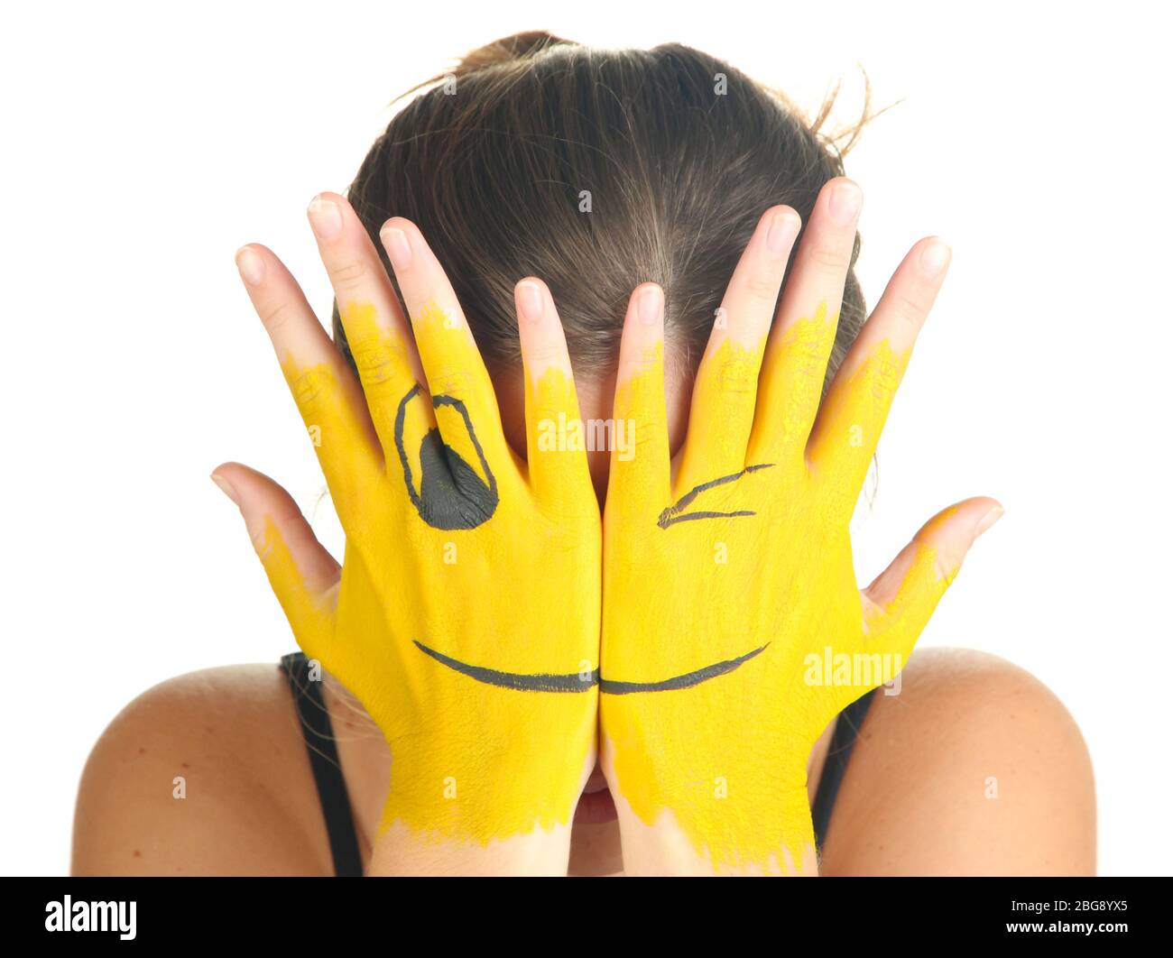 Portrait of girl hiding her face under smile mask isolated on white ...