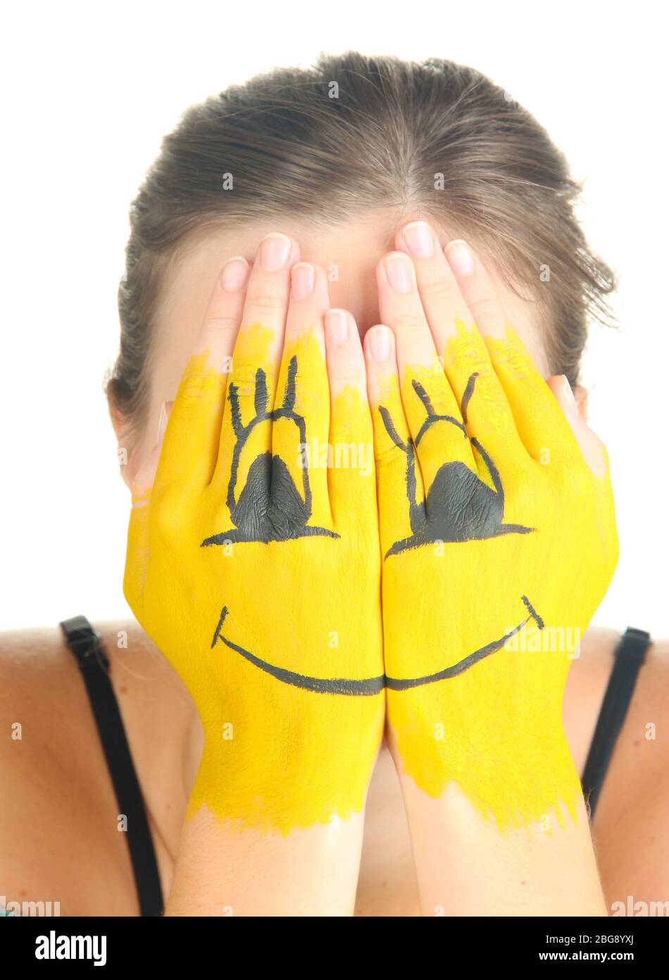 Portrait of girl hiding her face under smile mask isolated on white ...