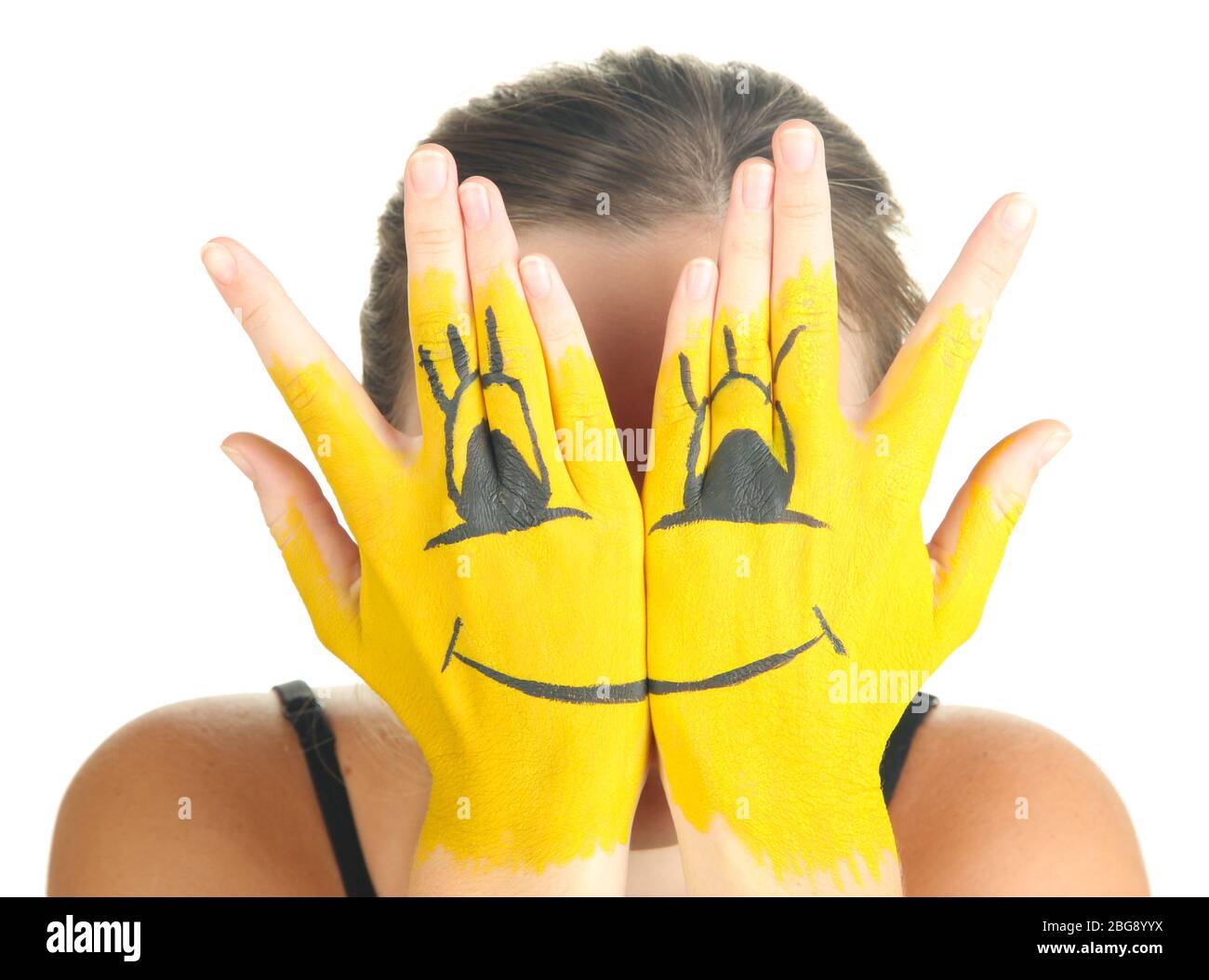 Portrait of girl hiding her face under smile mask isolated on white ...