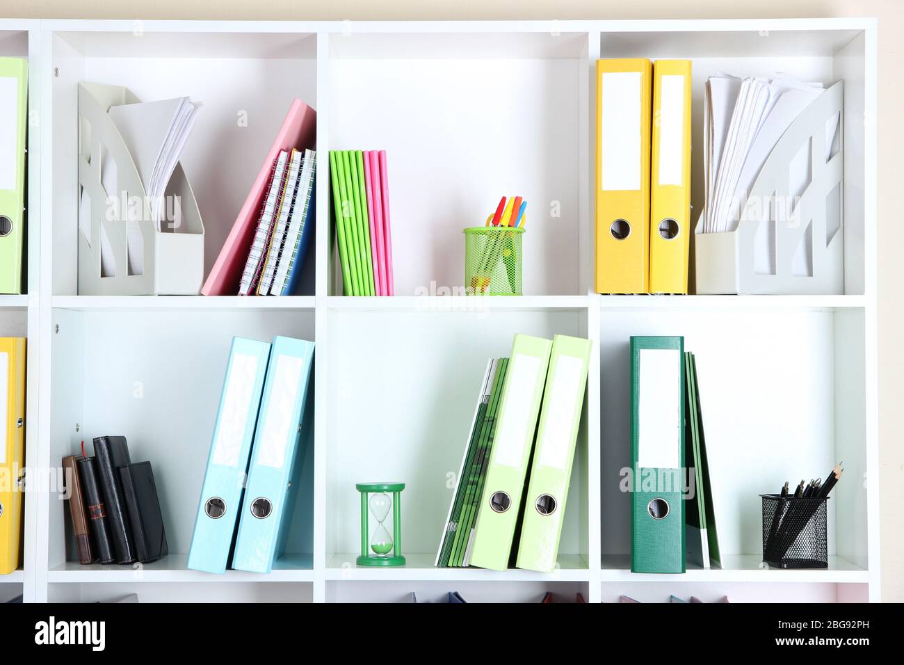 White office shelves with folders and different stationery, close up ...