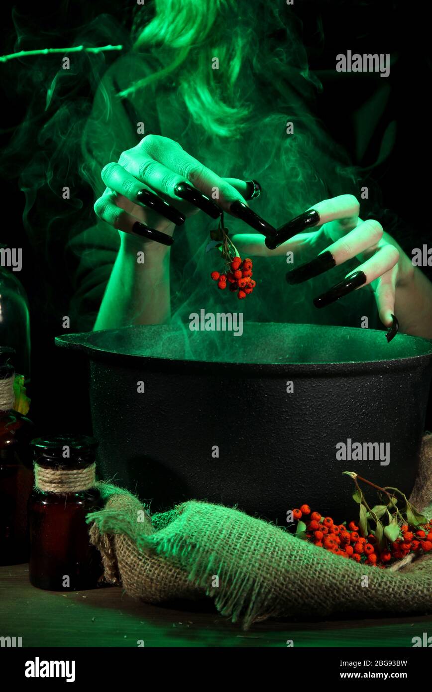 Witch in scary Halloween laboratory on dark color background Stock ...