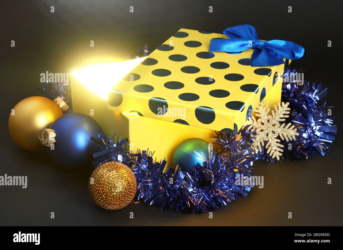 Gift box with bright light on it on dark grey background Stock Photo ...