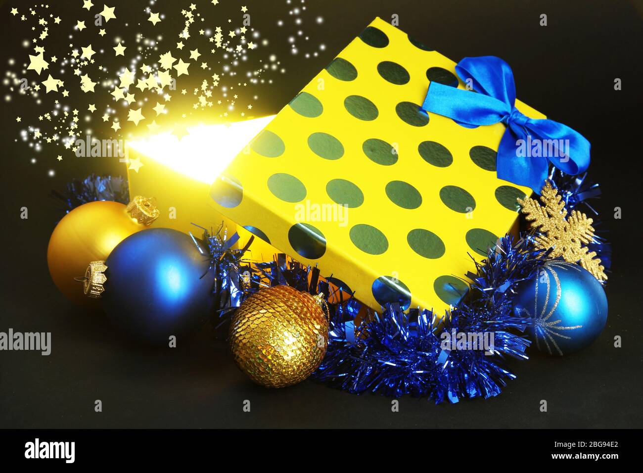 Gift box with bright light on it on dark grey background Stock Photo ...