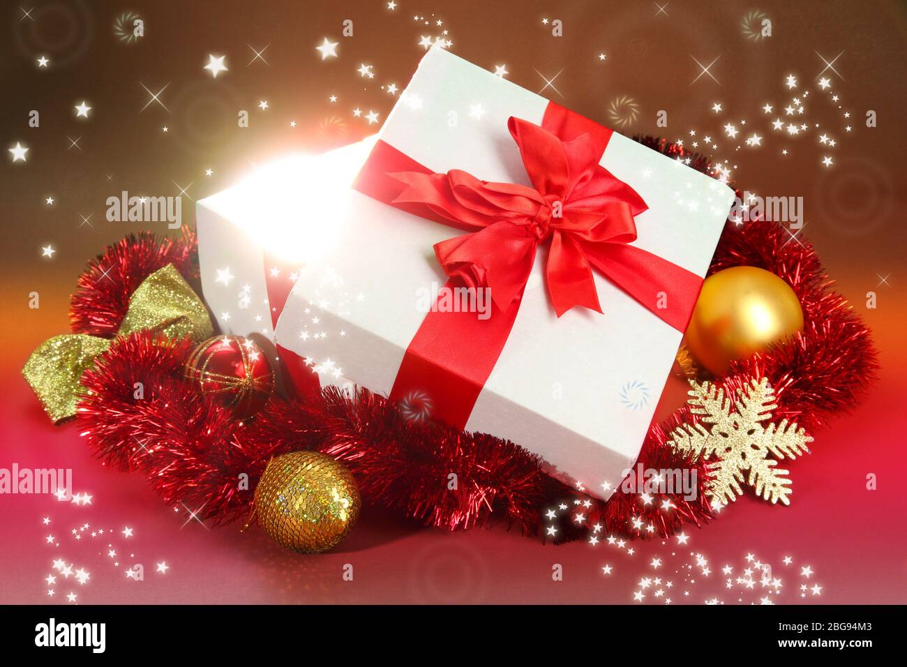 Gift box with bright light on it on bright background Stock Photo - Alamy