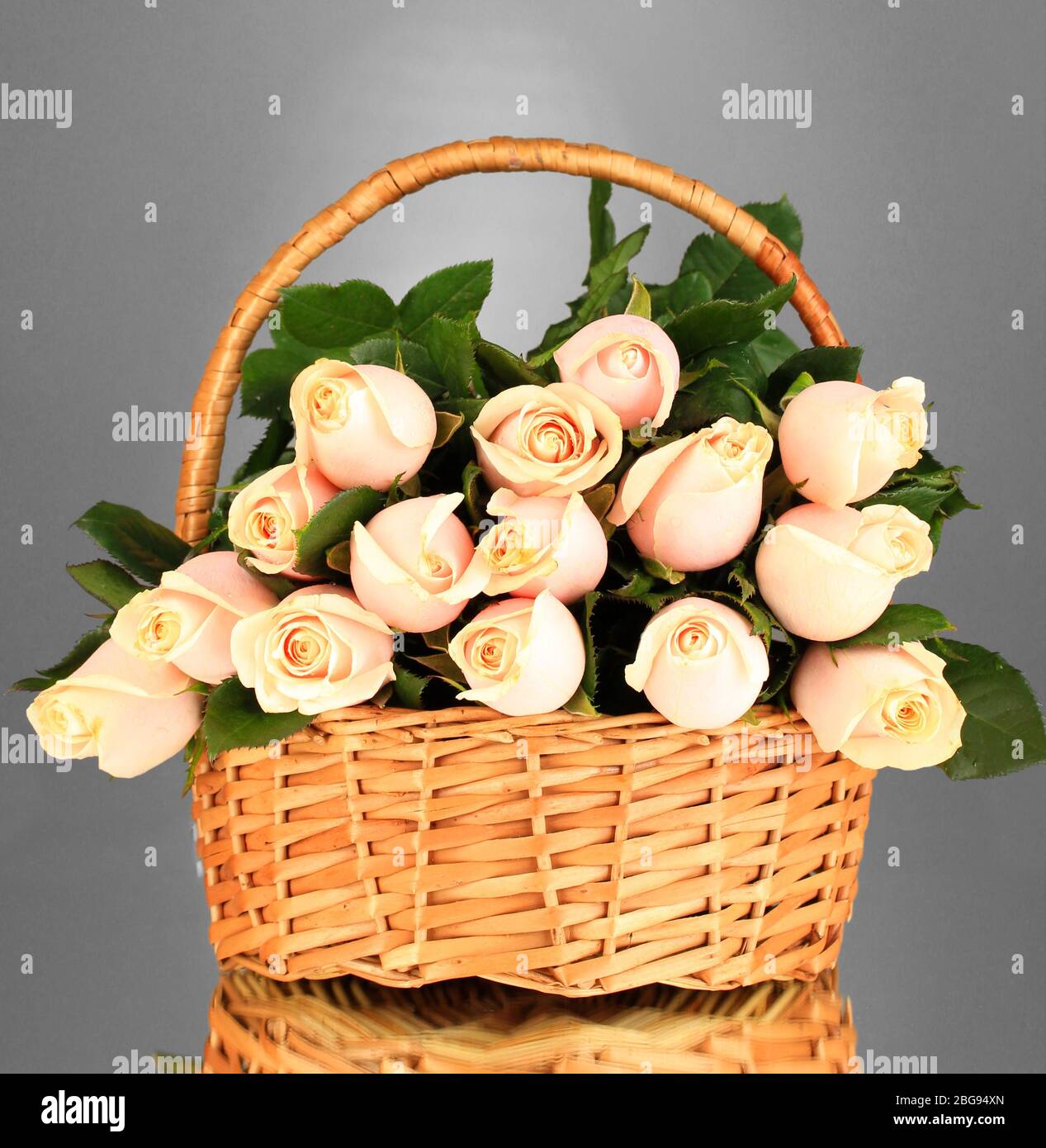 Beautiful bouquet of roses in basket on grey background Stock Photo - Alamy
