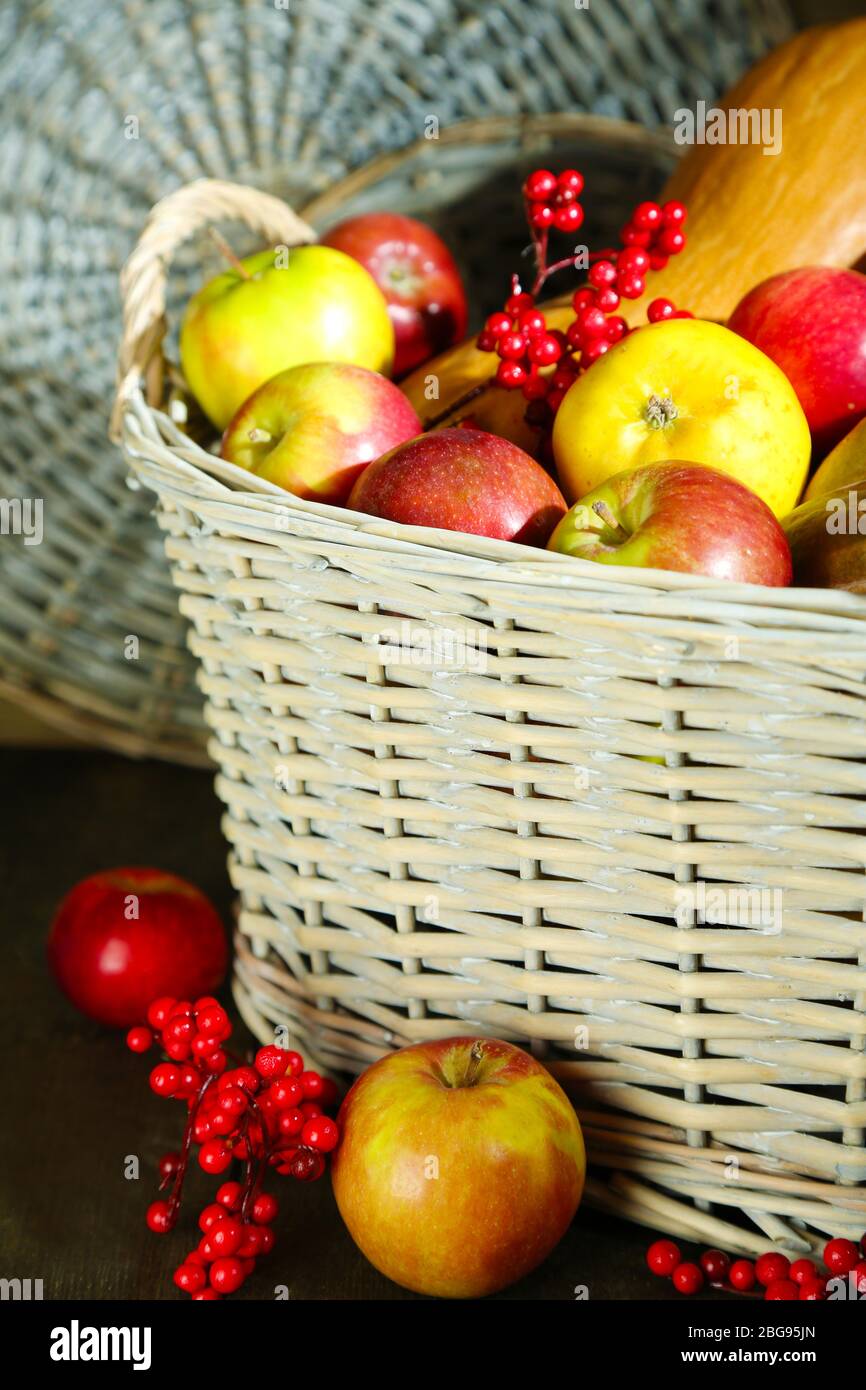Juicy apples and pumpkin in wooden basket on table close-up Stock Photo ...