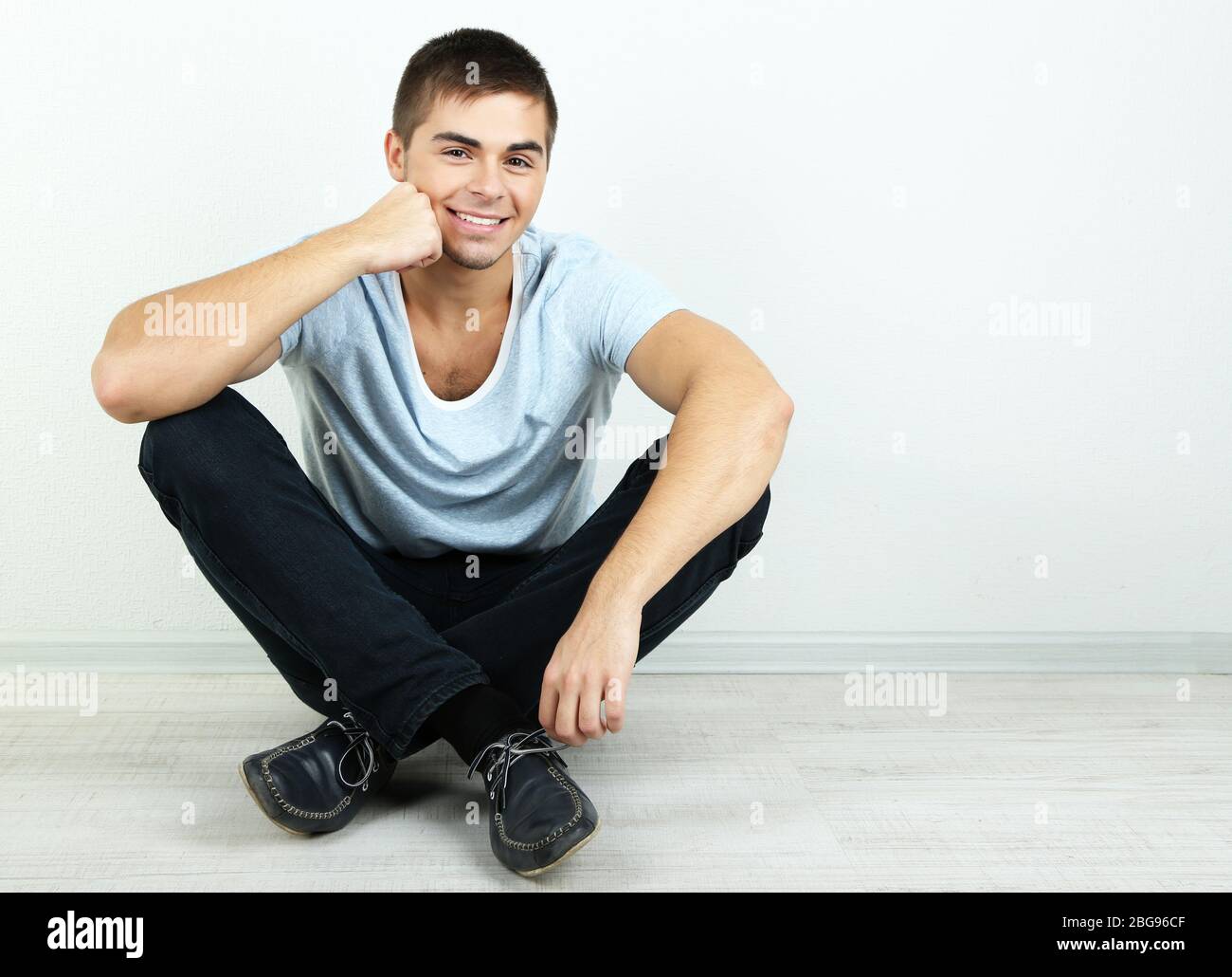 Guy sitting on floor in room Stock Photo - Alamy
